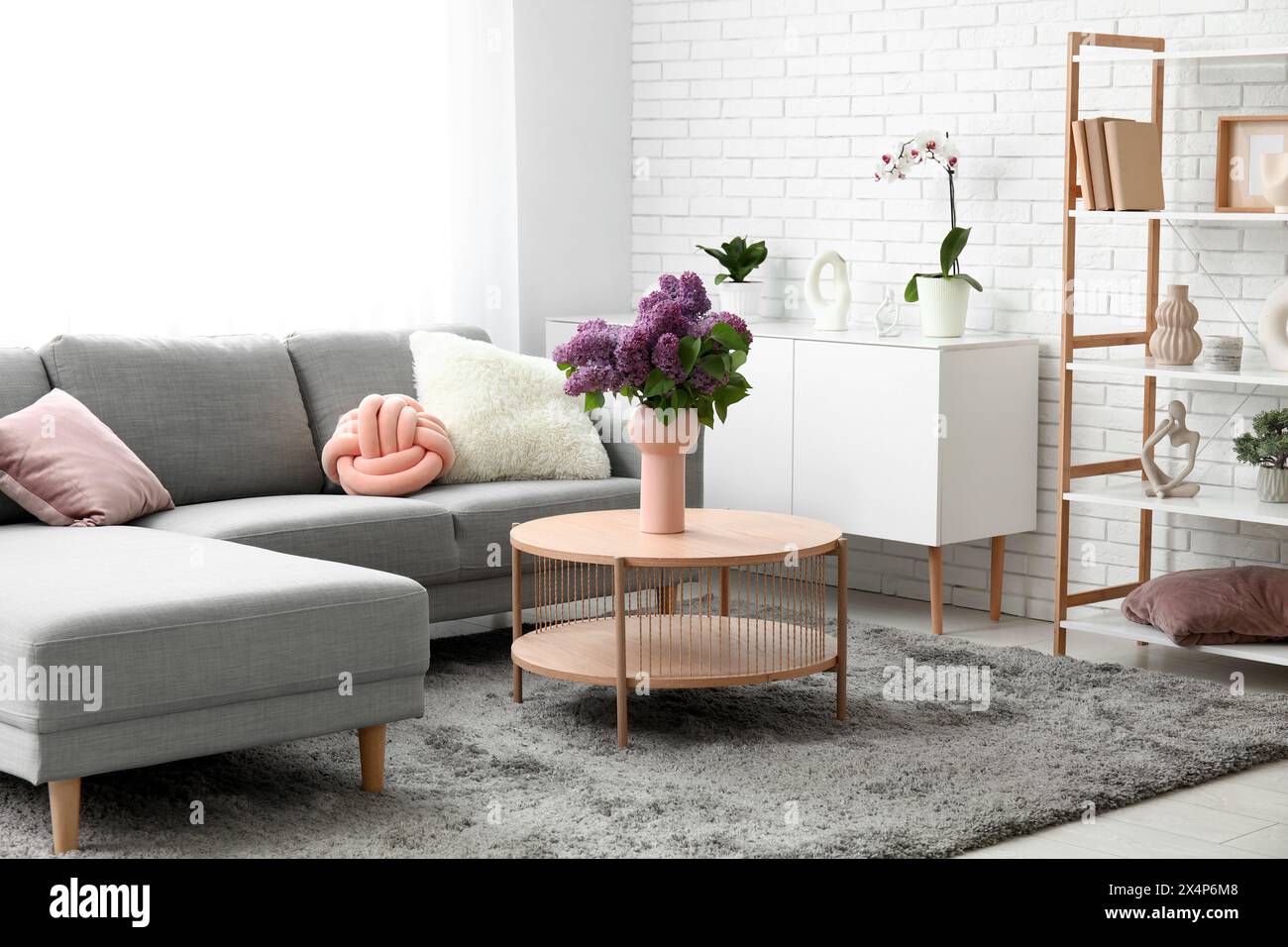 Beautiful interior of living room with bouquet of lilacs branches on ...