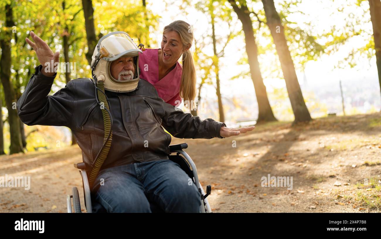 Elderly man in an astronaut helmet extends his arms in a flying gesture ...
