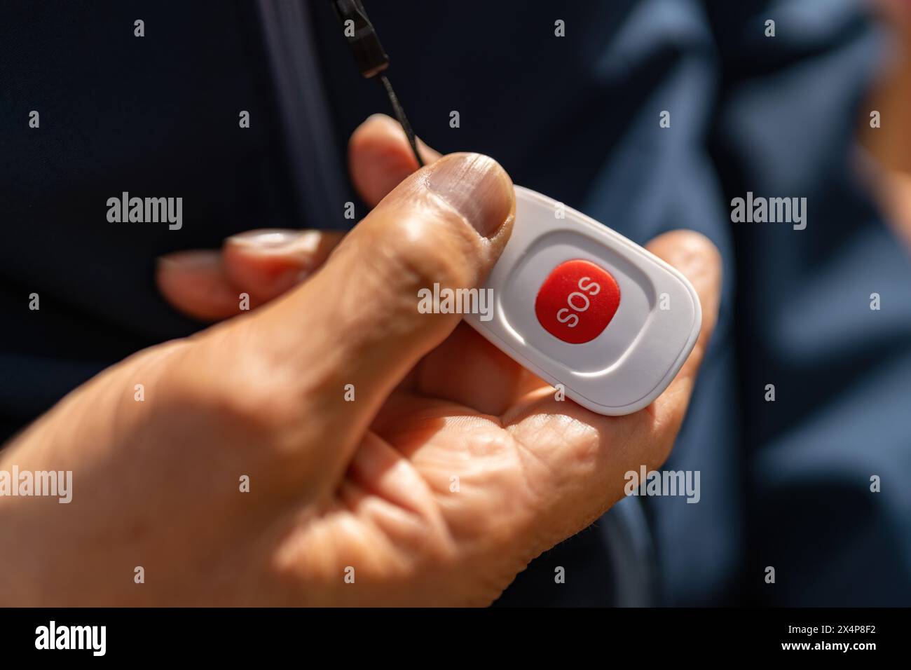 old hand holding an SOS button, highlighting its use for emergencies ...