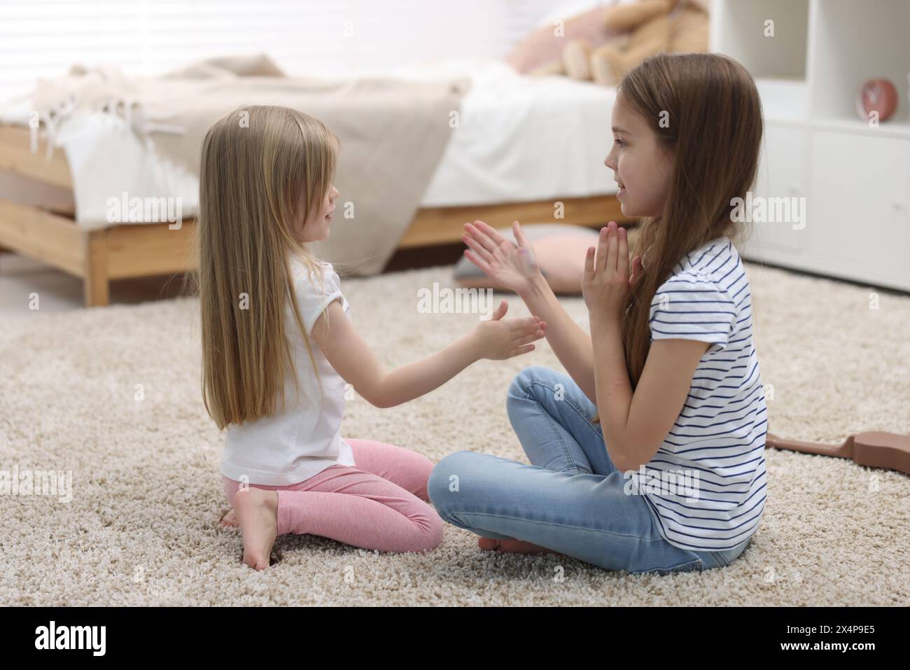 Cute little sisters playing clapping game with hands at home Stock Photo - Alamy