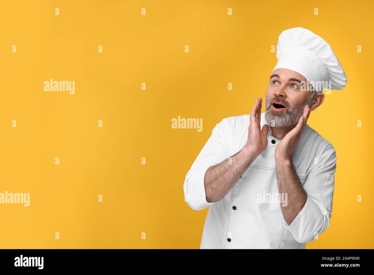 Surprised chef in uniform on orange background, space for text Stock ...