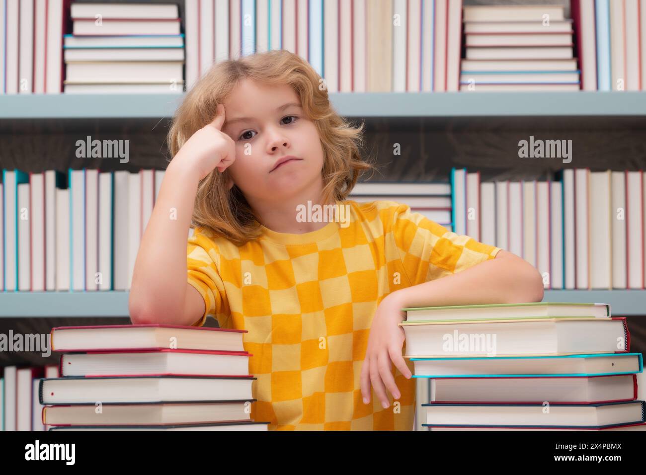 Thinking school kid. Schoolboy pupil reading book at school. Kid doing ...