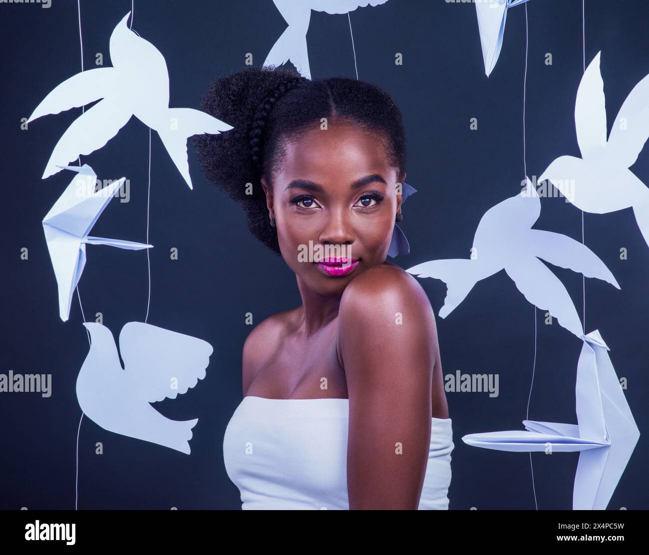 African woman, studio and portrait on black background, paper birds and ...