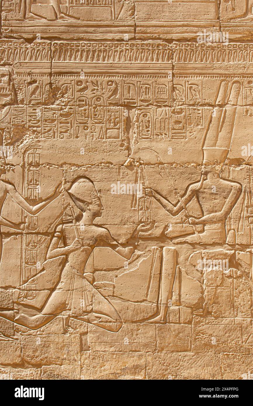 Detail of a relief of pharaoh Ramses II kneeling before the Theban god ...