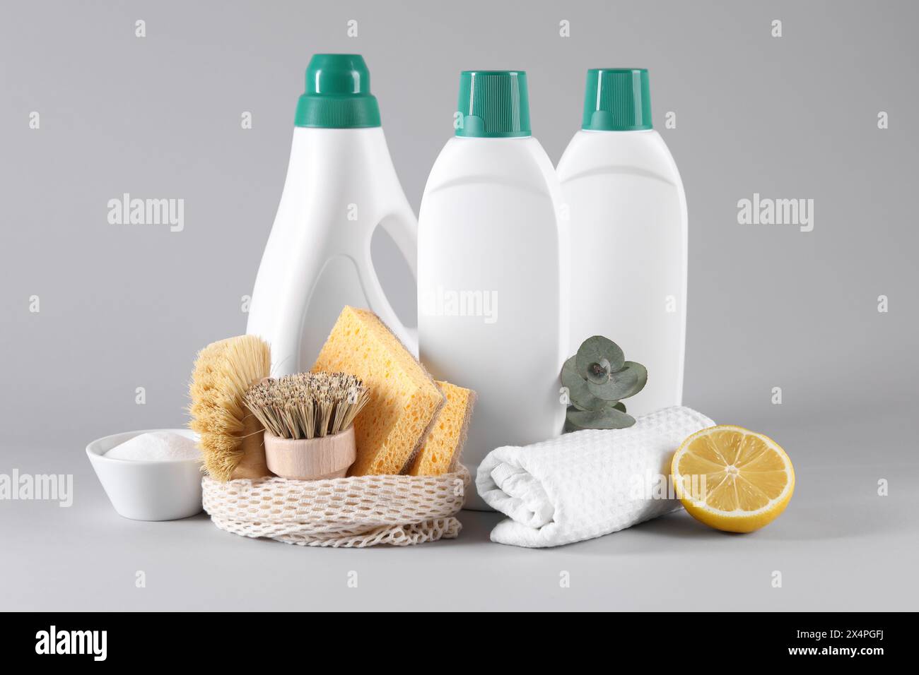 Bottles of cleaning product, sponges, brushes, lemon and baking soda on ...