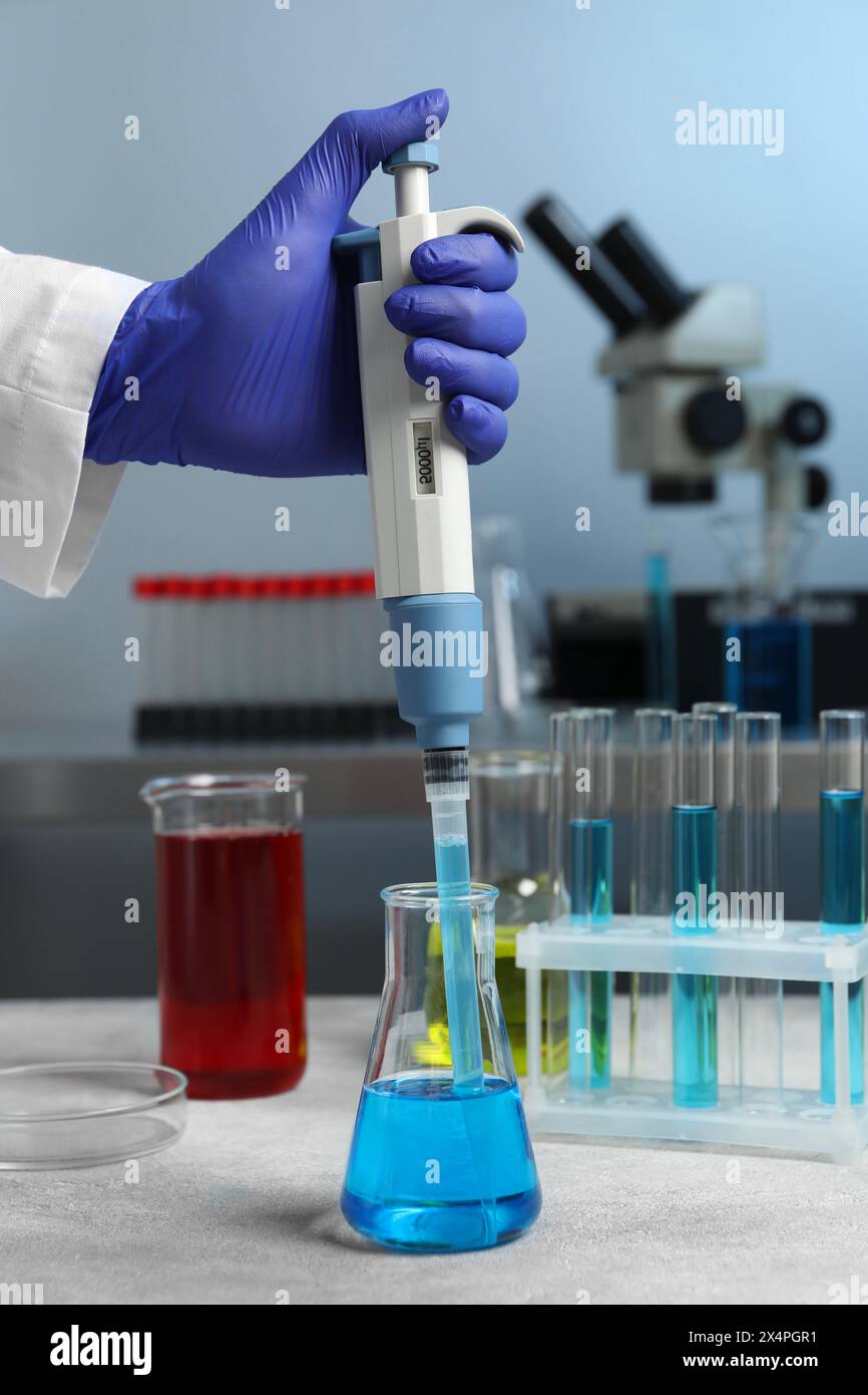 Laboratory analysis. Scientist dripping sample with micropipette into ...