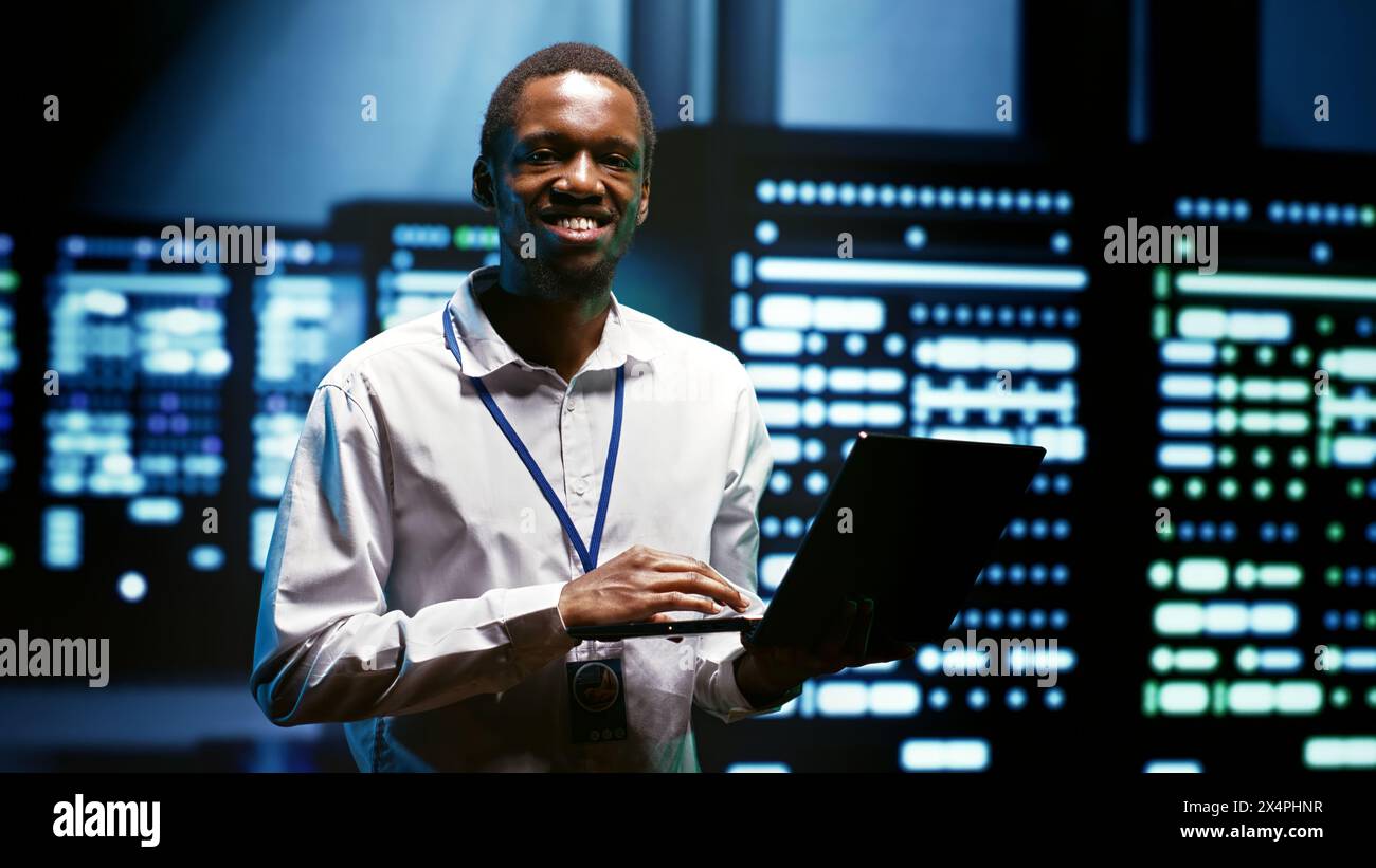 System administrator using laptop to audit servers in high tech facility providing computing ...