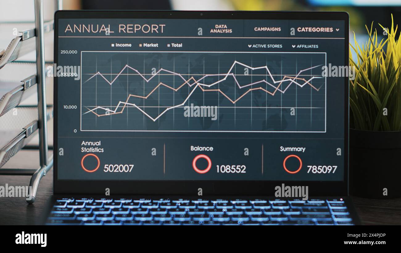 Business diagram and figures on laptop left open on desk in empty ...