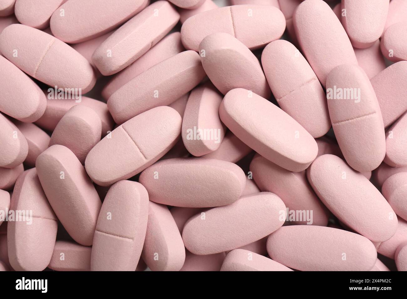 Pink vitamin capsules as background, top view Stock Photo - Alamy