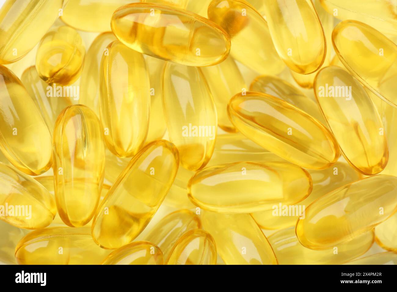 Yellow vitamin capsules as background, top view Stock Photo - Alamy