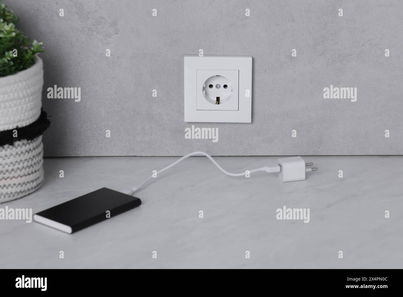 Electric socket and power bank on white table Stock Photo - Alamy