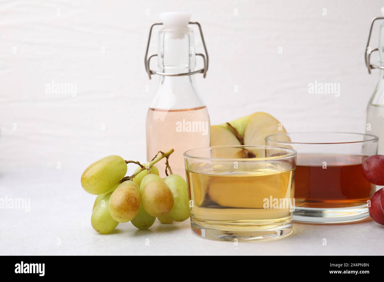 Different types of vinegar and ingredients on light table, closeup ...