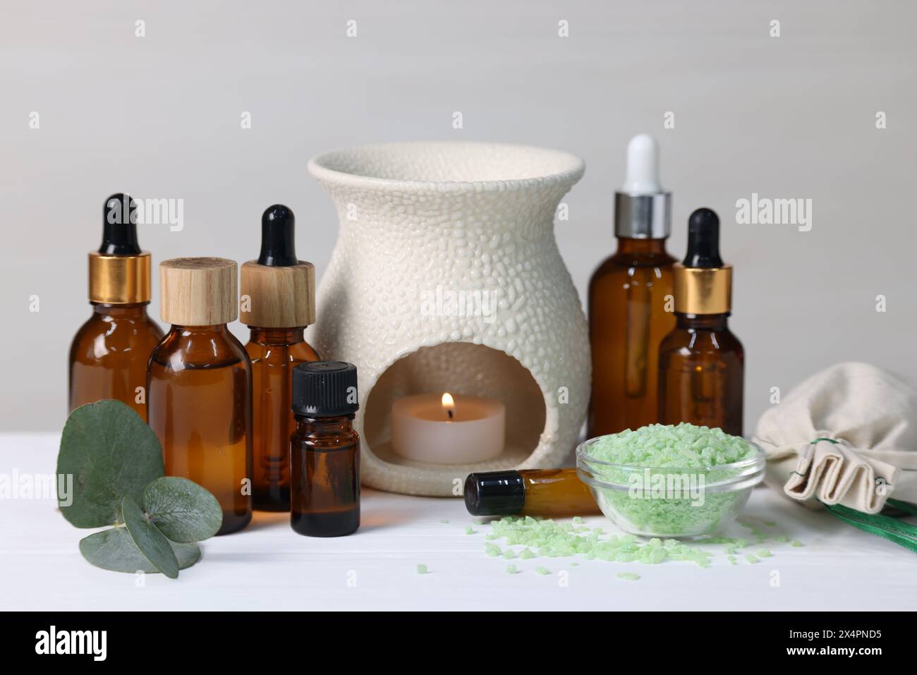 Different aromatherapy products, burning candle and eucalyptus leaves ...