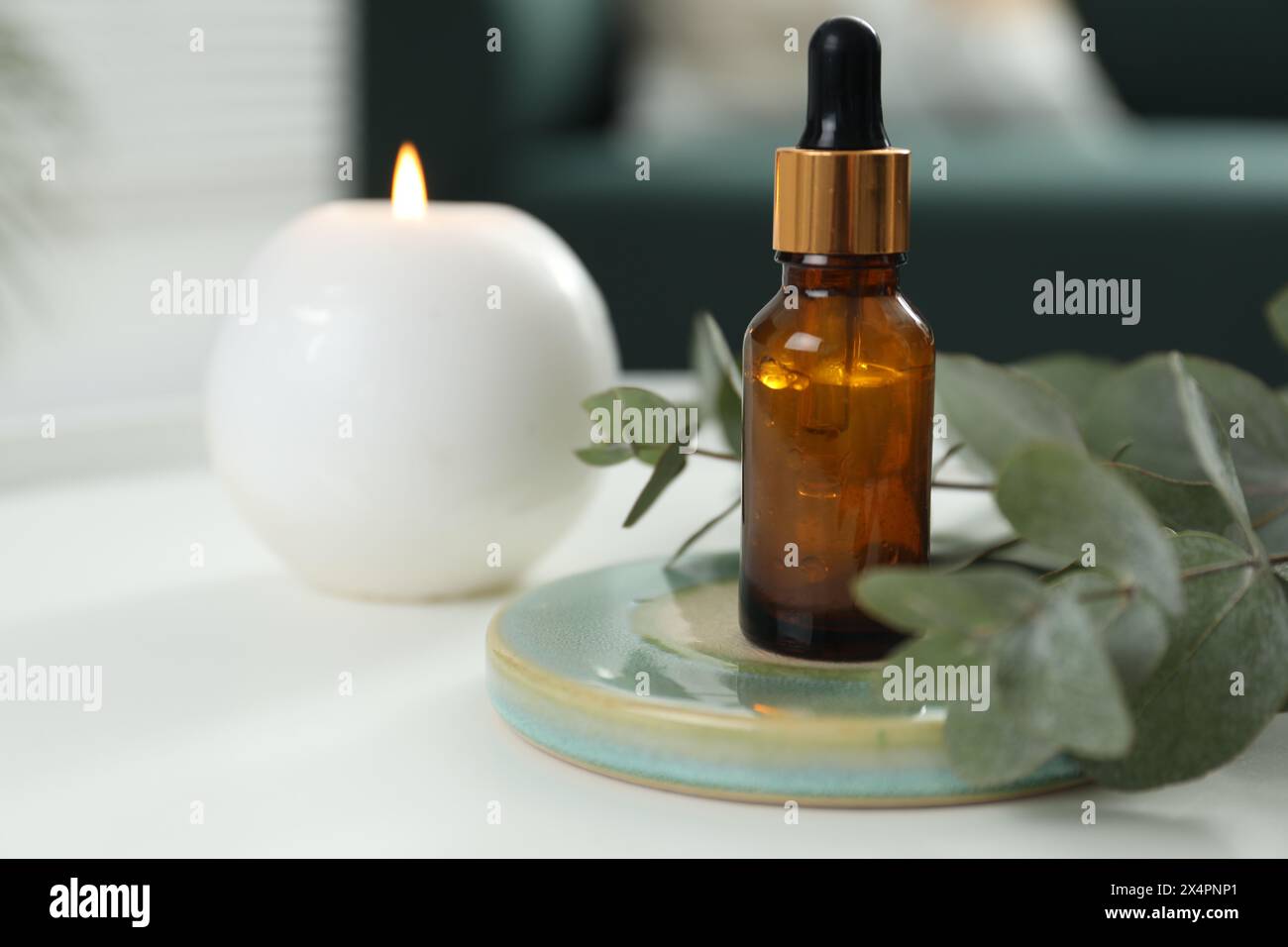 Aromatherapy. Bottle of essential oil, burning candle and eucalyptus ...