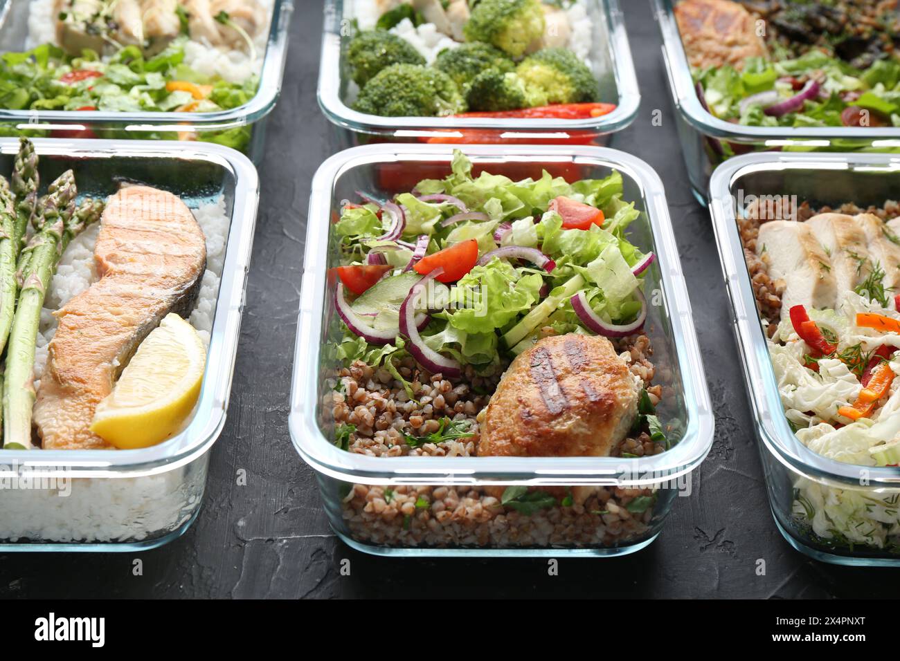 Healthy food. Different meals in glass containers on black table Stock ...