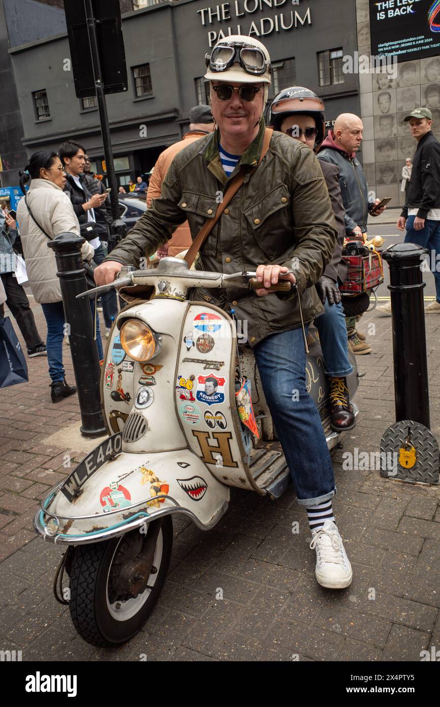 A classic scooter owner rides on a London Street. Scooter owners ...