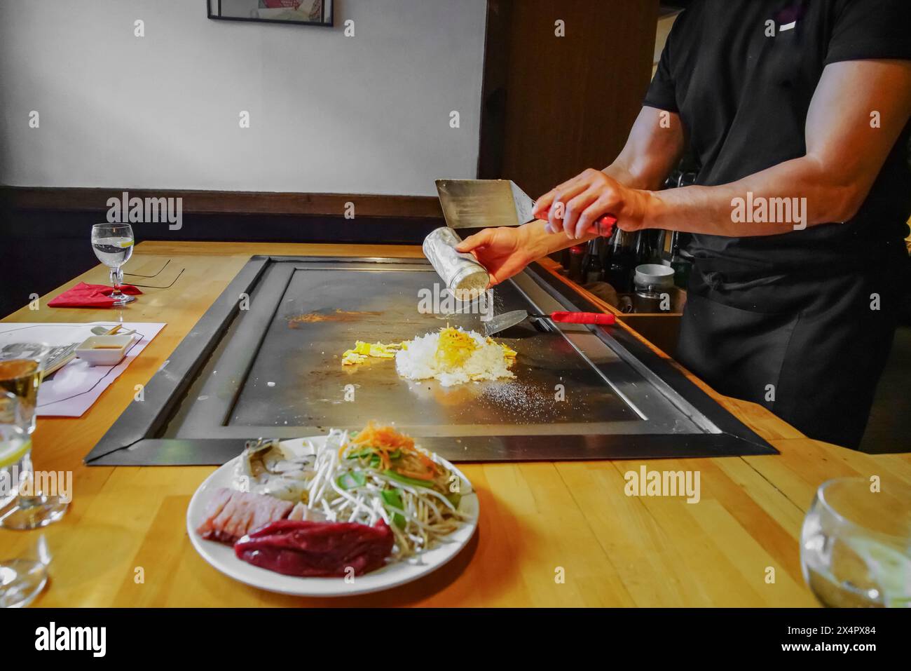 chef's hands with spatula over teppanyaki. cooking vegetables meat and ...