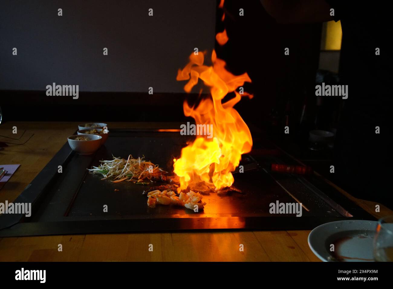 chef's hands with spatula over teppanyaki. cooking vegetables meat and ...
