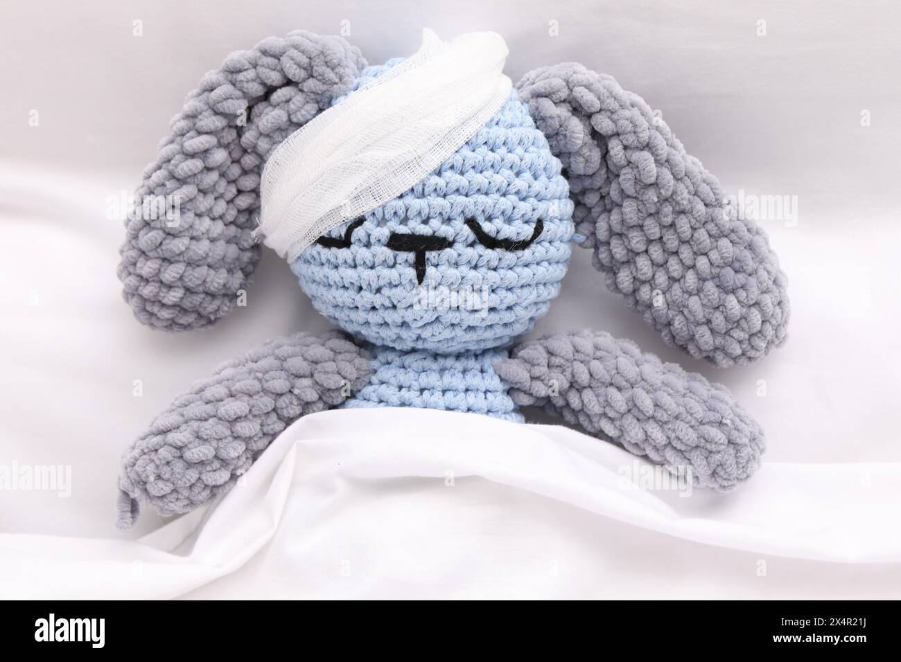 Toy cute bunny with bandage under blanket in bed Stock Photo - Alamy
