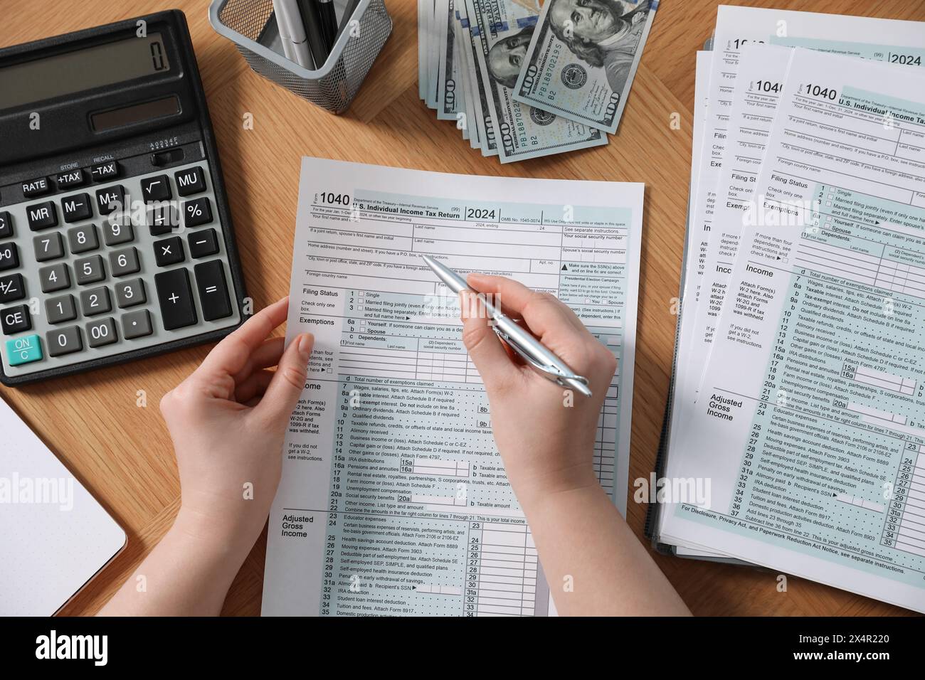 Payroll. Woman working with tax return forms at wooden table, top view ...