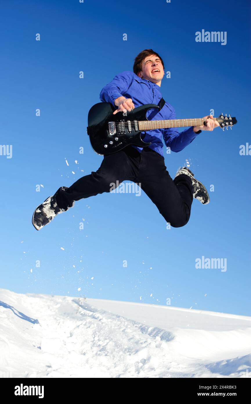 Emotional jumping singer with electro guitar Stock Photo - Alamy