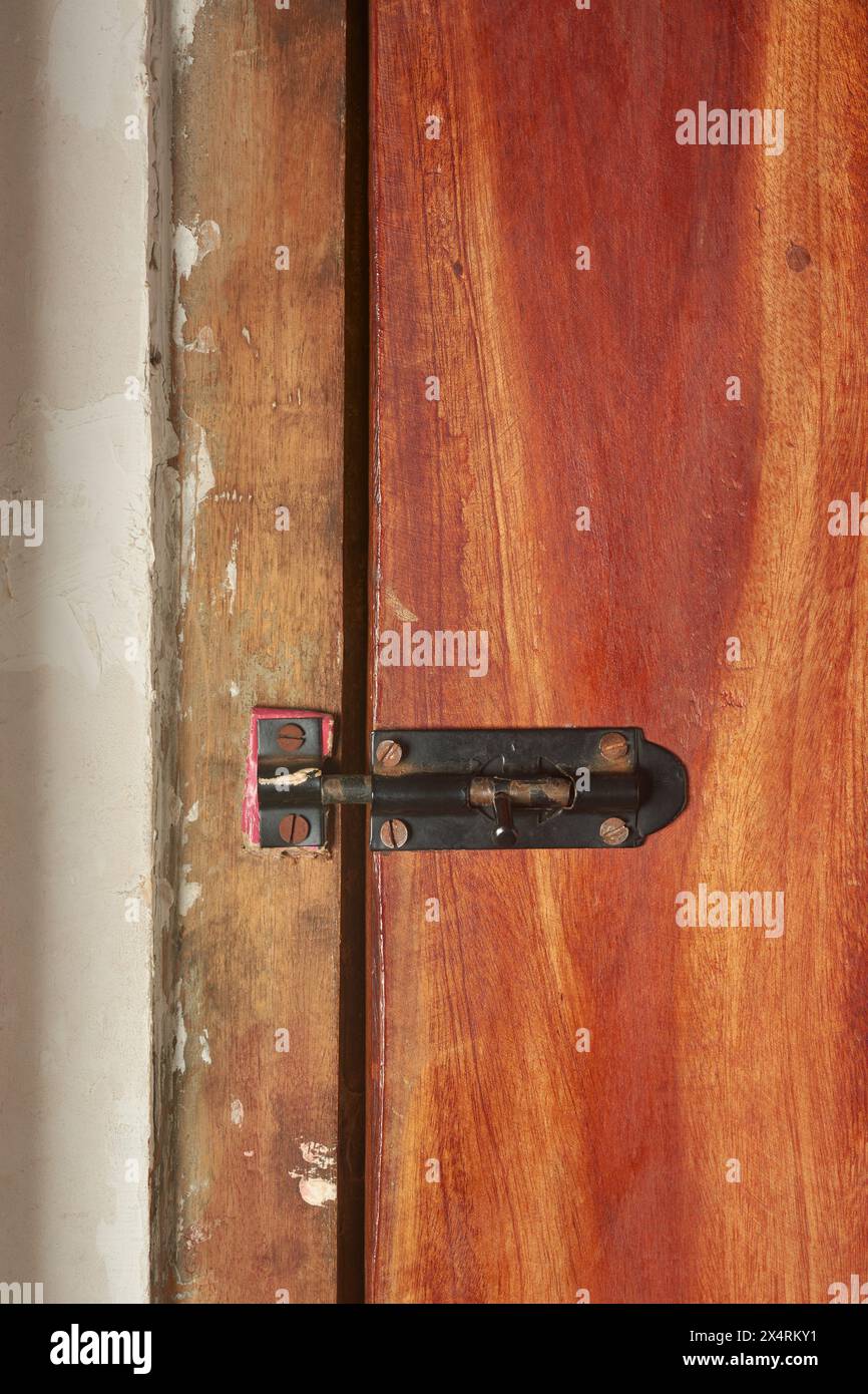 simple wooden door lock or latch fixed on wood door surface close-up ...