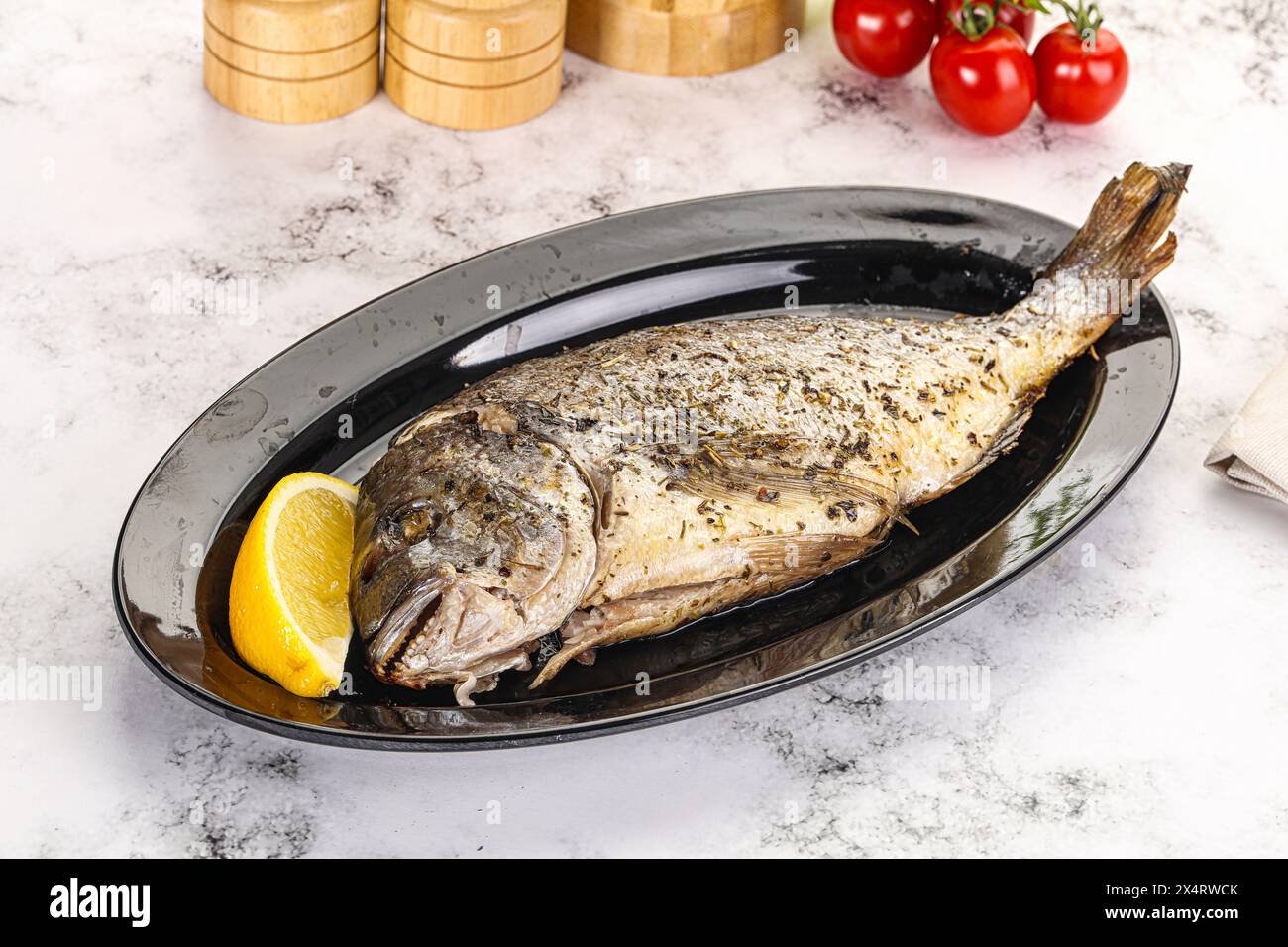 Baked Dorado fish served lemon slice Stock Photo - Alamy