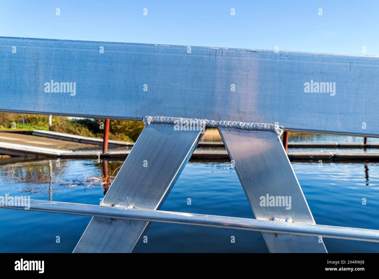 Detail of a section of a shiny metal rail on a dock at Tenmile Lake in ...