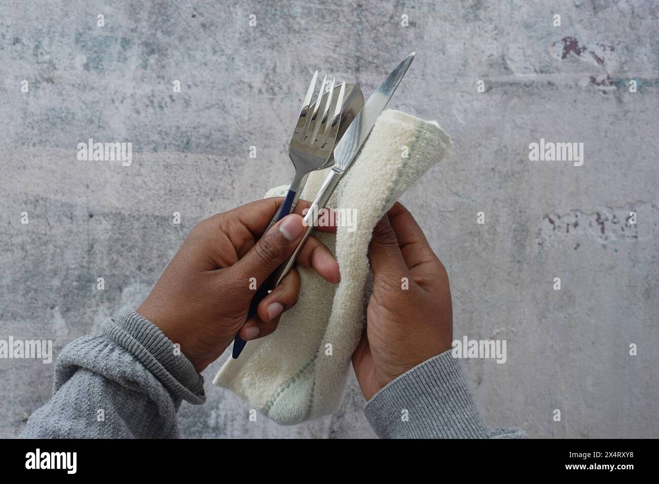 person hand cleaning and drying cutlery with a towel Stock Photo - Alamy