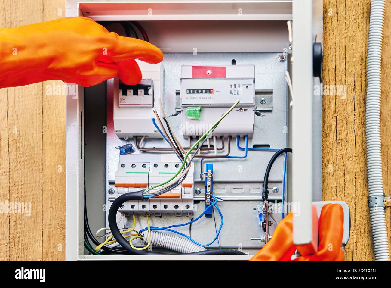 An electrician wearing protective dielectric gloves turns off power ...