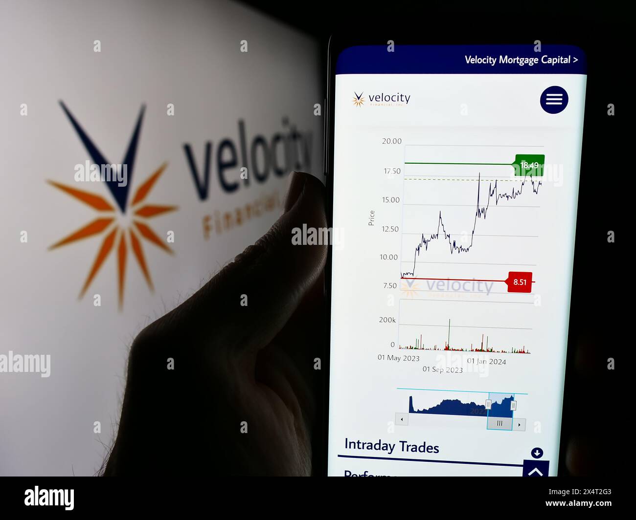 Person holding cellphone with webpage of US real estate finance company ...