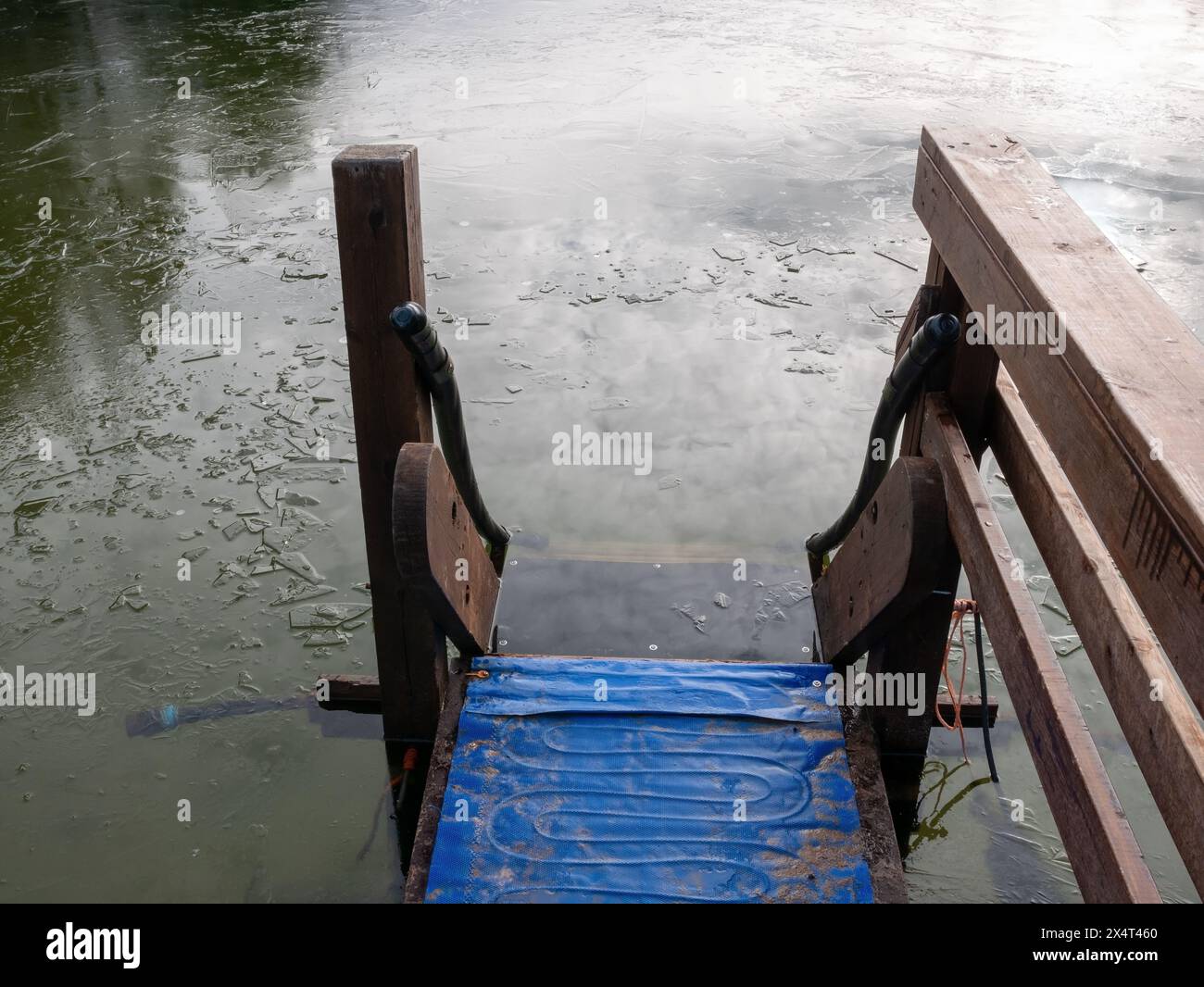 Swimming pool hand-rails and ladder leading into freezing pond, Finland ...