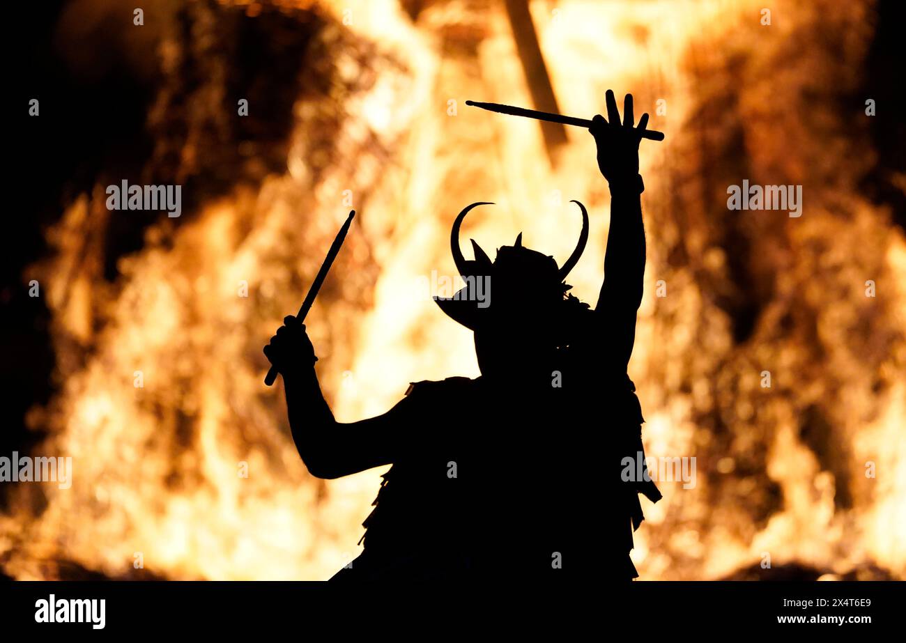 A member of the Pentacle Drummers performs in front of a burning wicker ...