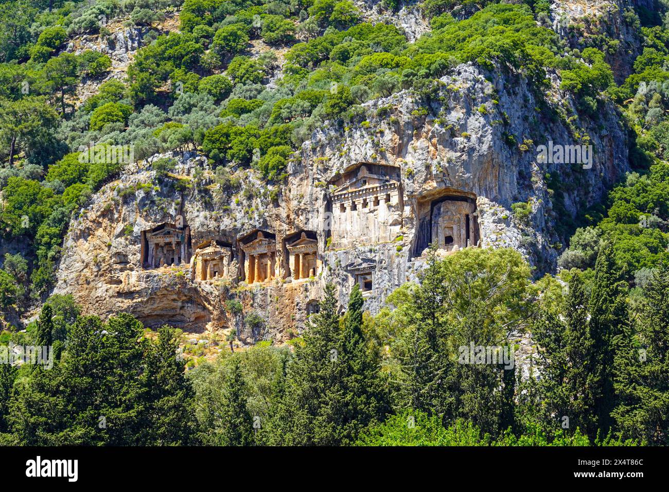 Tourist river boats and Royal Lycian tombs carved into rock face, at ...