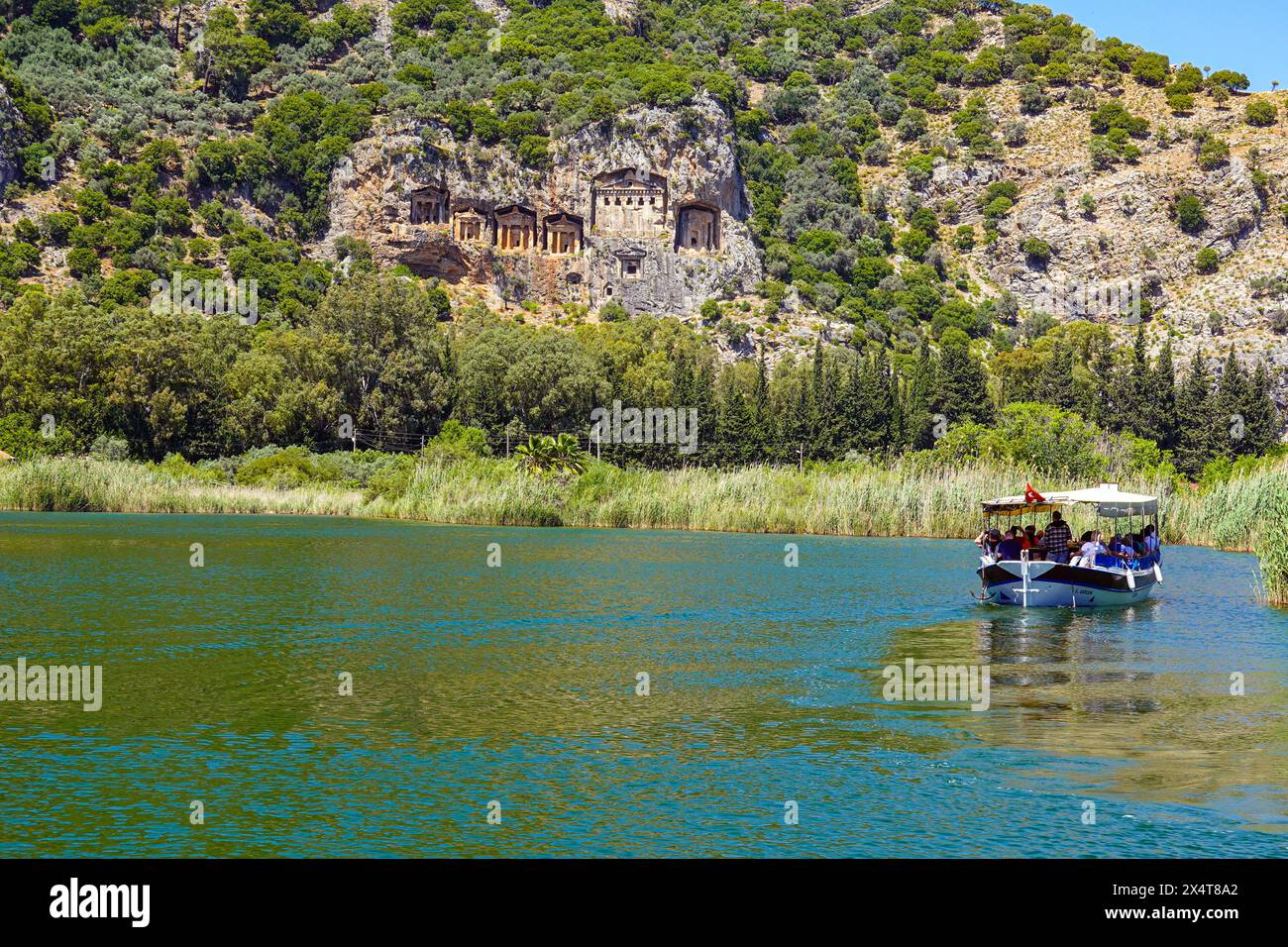 Tourist river boats and Royal Lycian tombs carved into rock face, at ...