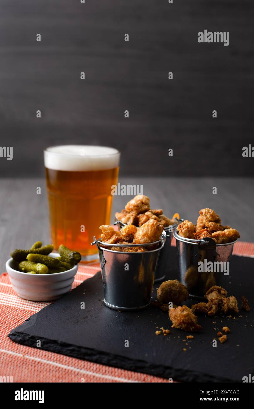 English pub snack of salted pork rind scratchings in miniature buckets ...