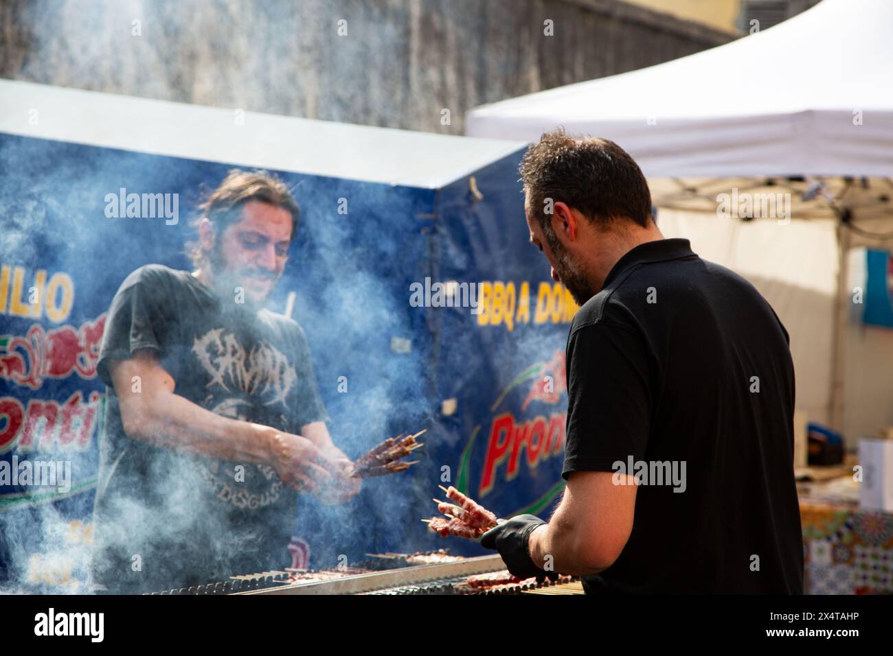 Outdoor barbecue with men grilling meat Stock Photo - Alamy