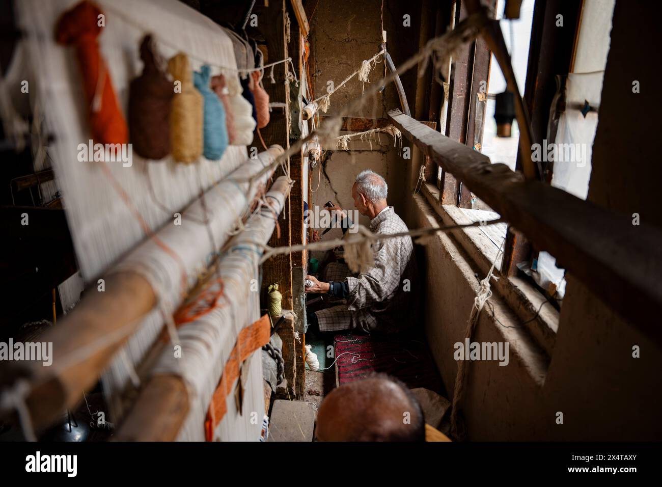 A Kashmiri artisan is seen weaving a traditional carpet in a carpet ...