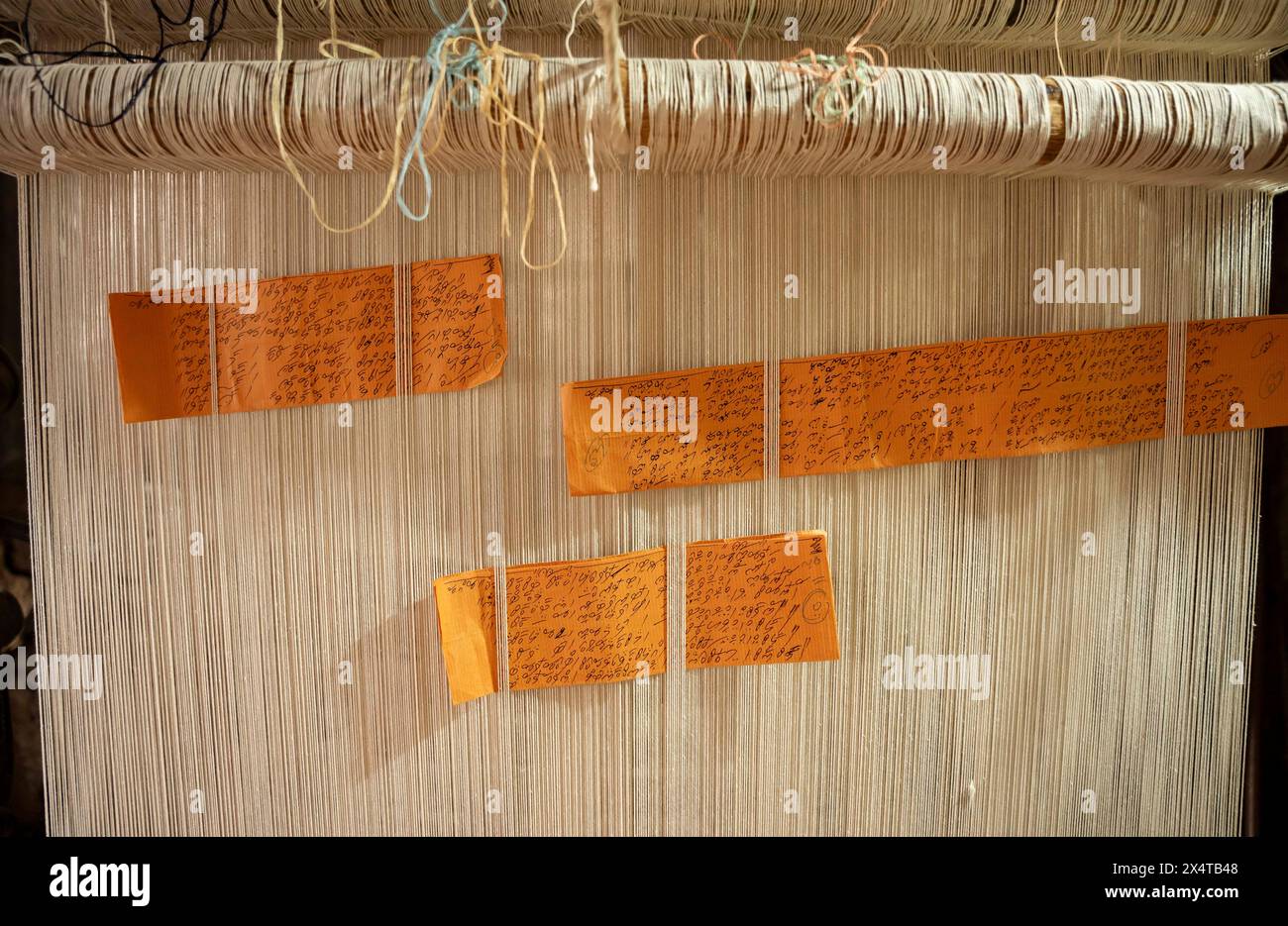 Designs are written on papers hanged on a traditional carpet threads ...