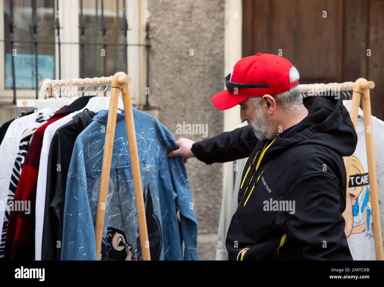 Male selecting garments at street vendor Stock Photo - Alamy