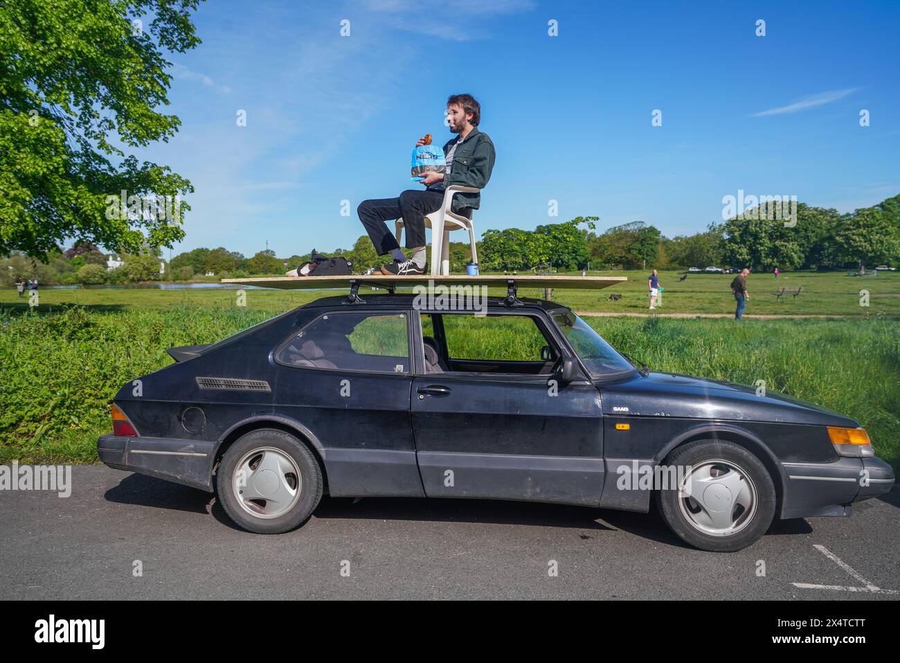 Wimbledon, London, UK. 5 May, 2024. A man sitting on top of a SAAB 900 ...