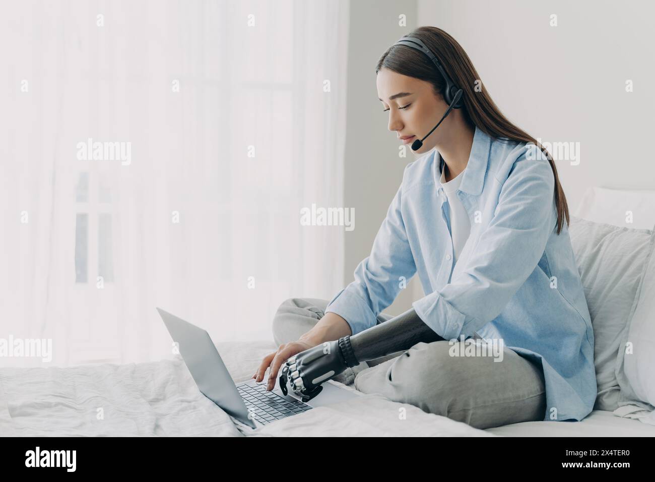 Professional woman works on laptop with a robotic arm, embodying a ...