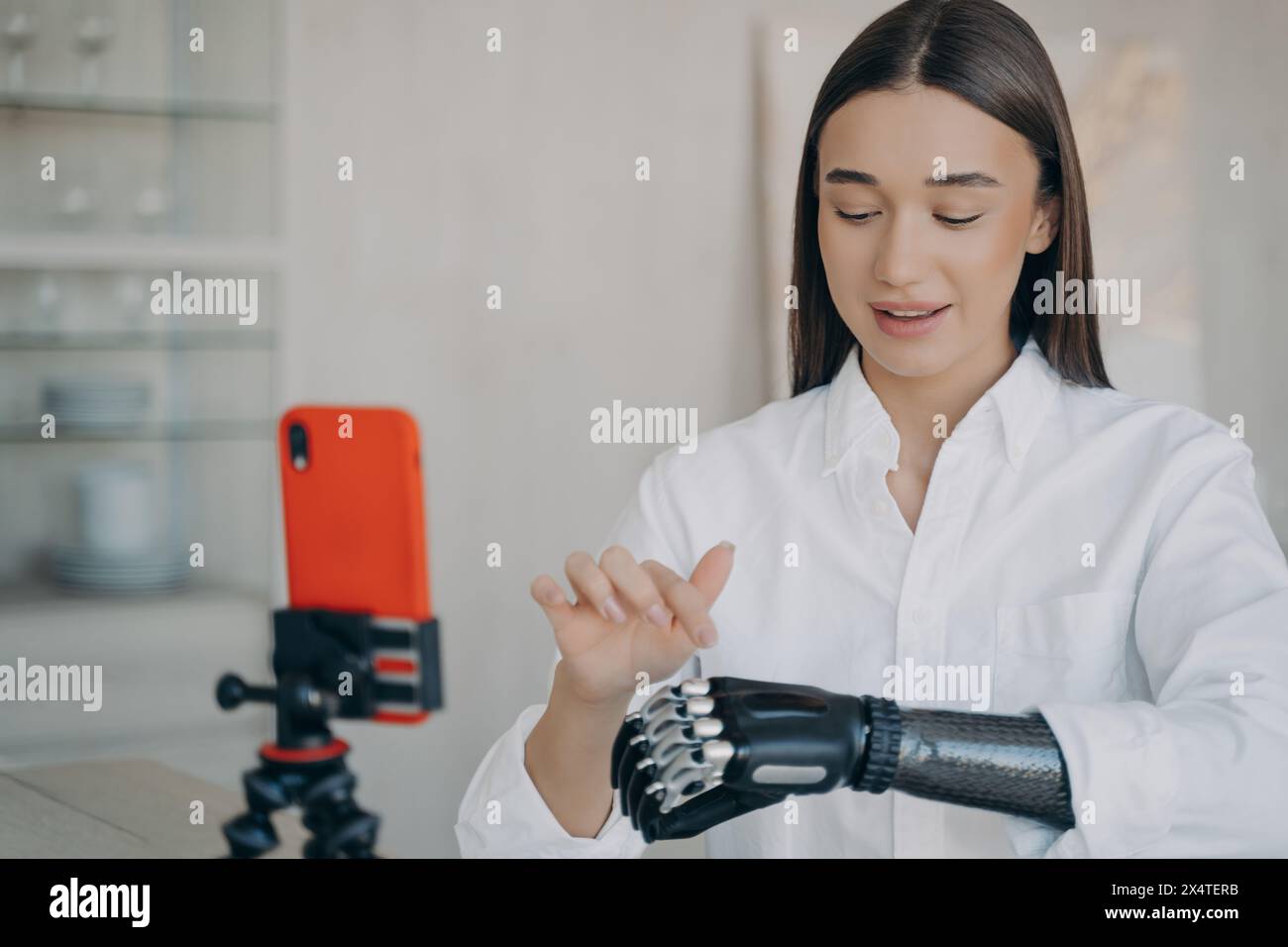 Young woman with a bionic arm checking the time, technology seamlessly ...