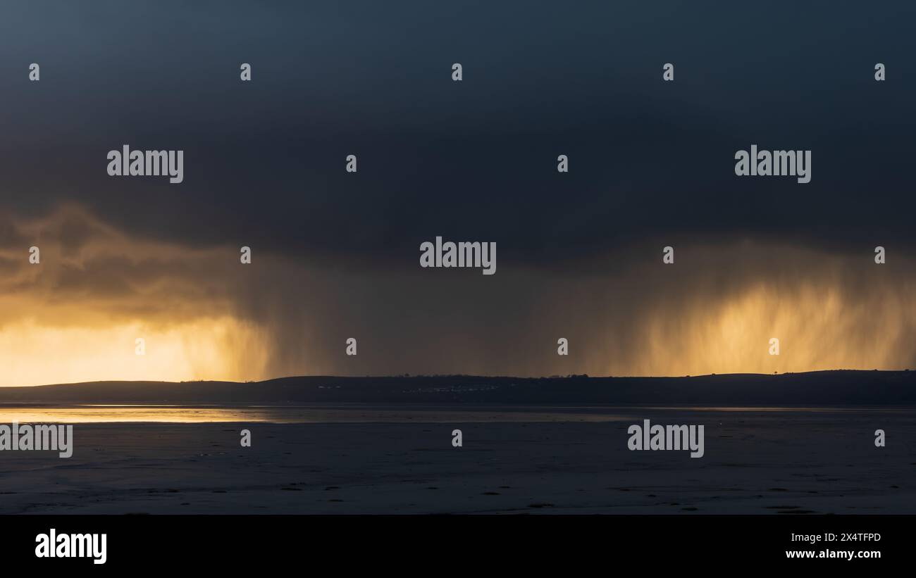 Stunning dramatic stormy skies over ocean landscape with distant heavy ...