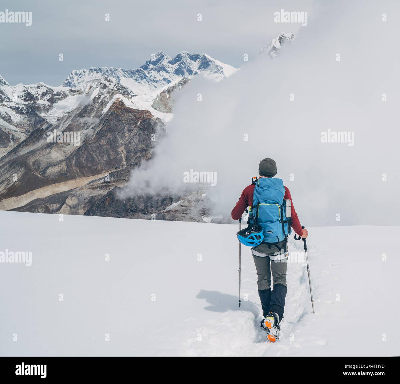 Climber with backpack and trekking poles descending Mera peak high ...