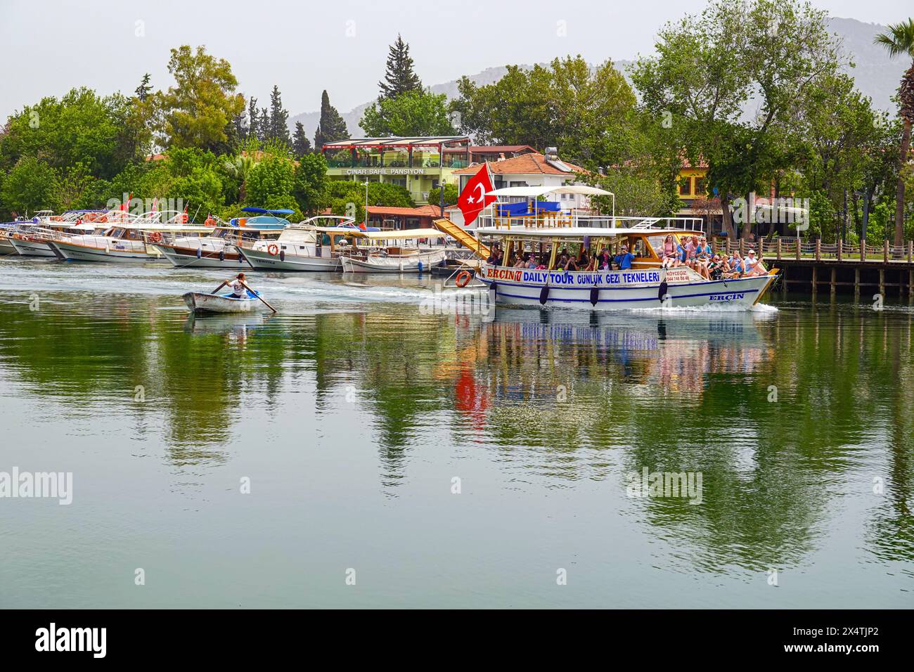 Tourist river boats and Royal Lycian tombs carved into rock face, at ...