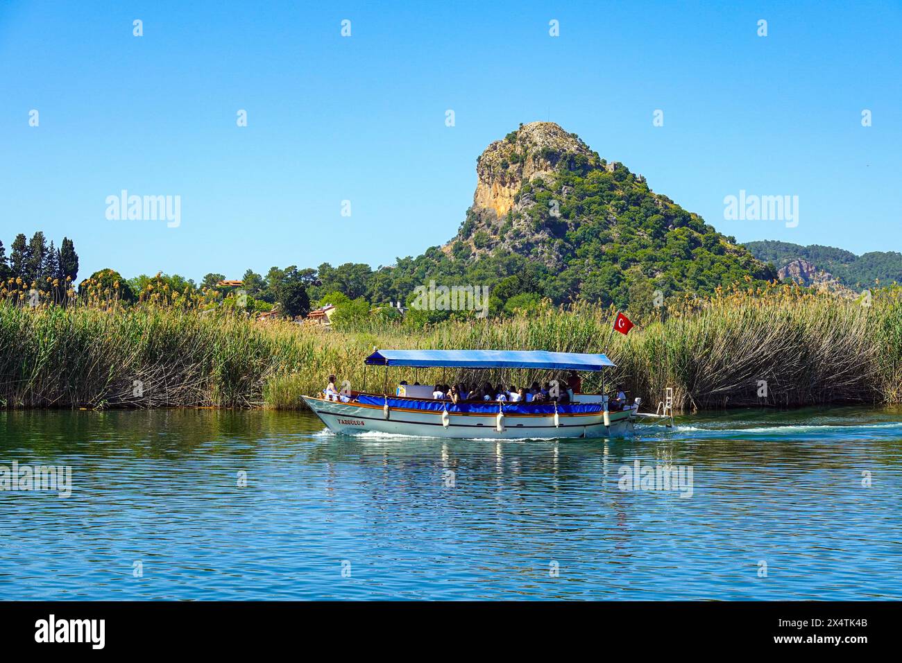 Tourist river boats and Royal Lycian tombs carved into rock face, at ...
