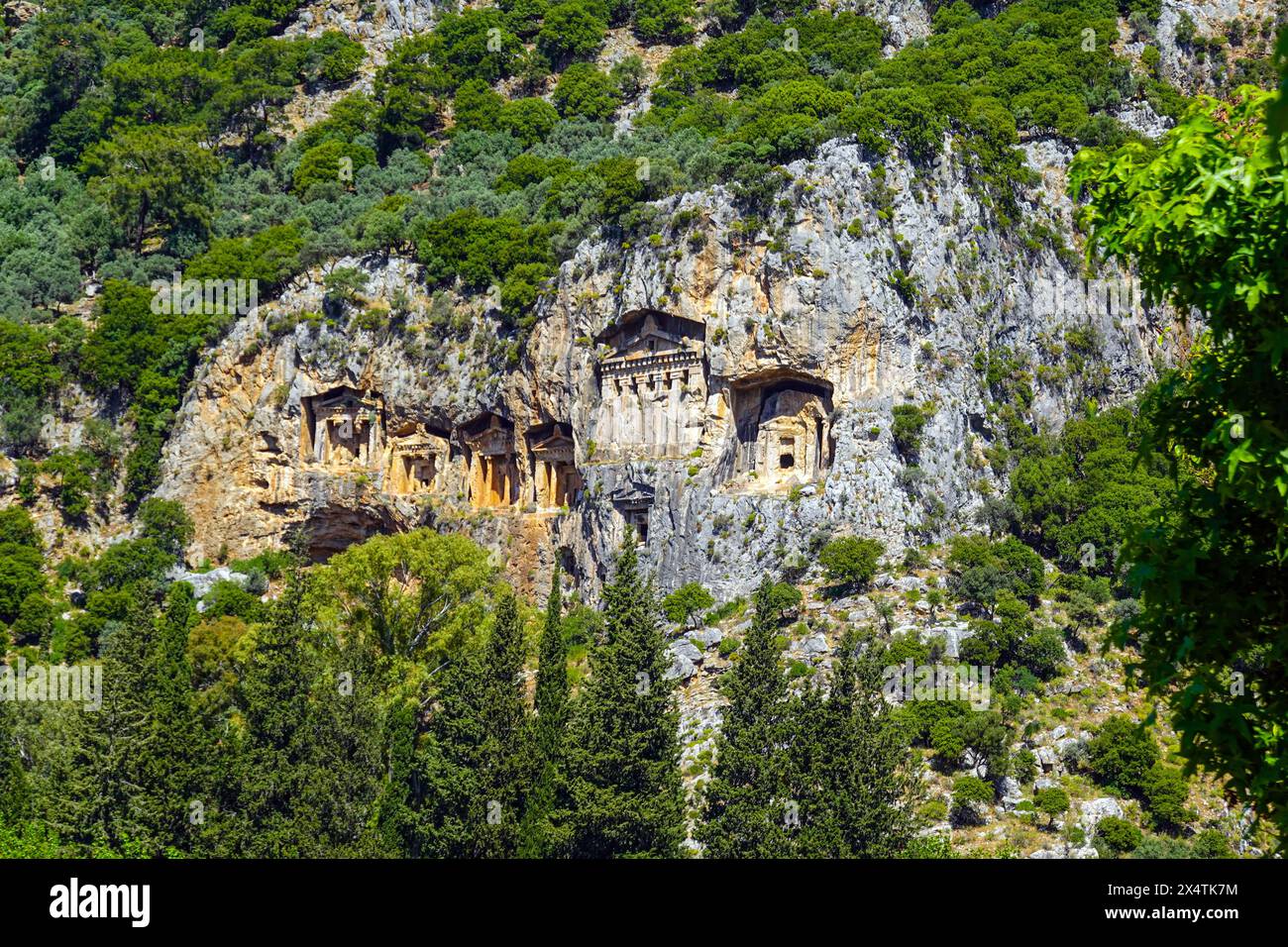 Tourist river boats and Royal Lycian tombs carved into rock face, at ...