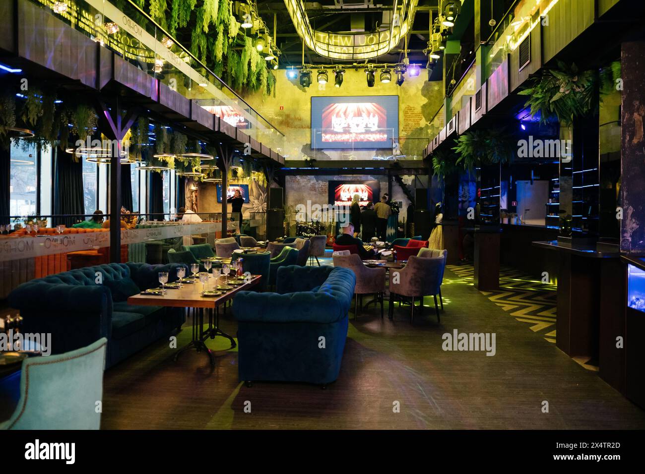 A restaurant with a large screen TV and a lot of seating. The TV is ...