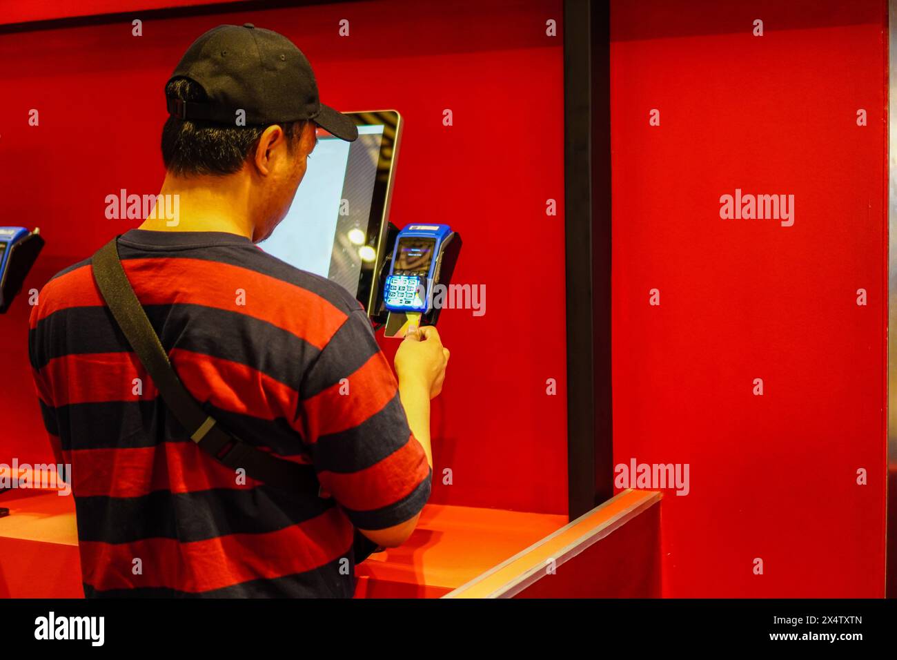 Man customer at store place orders and pay by credit card through self ...